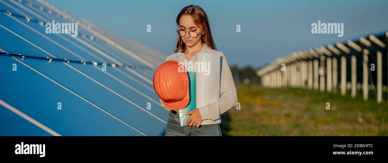 Beautiful young engineer standing near solar panels outdoors, Green ...