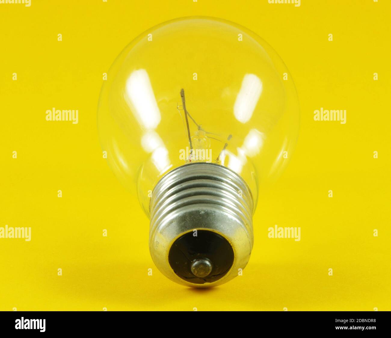 Light bulb closeup over yellow surface Stock Photo - Alamy