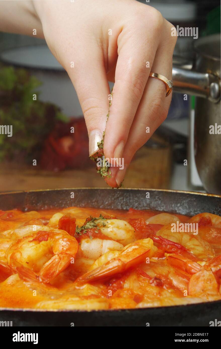 adding herbs to delicious prawns Stock Photo - Alamy