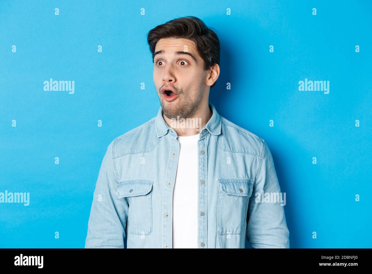 Close-up of surprised handsome man looking impressed left, open mouth ...