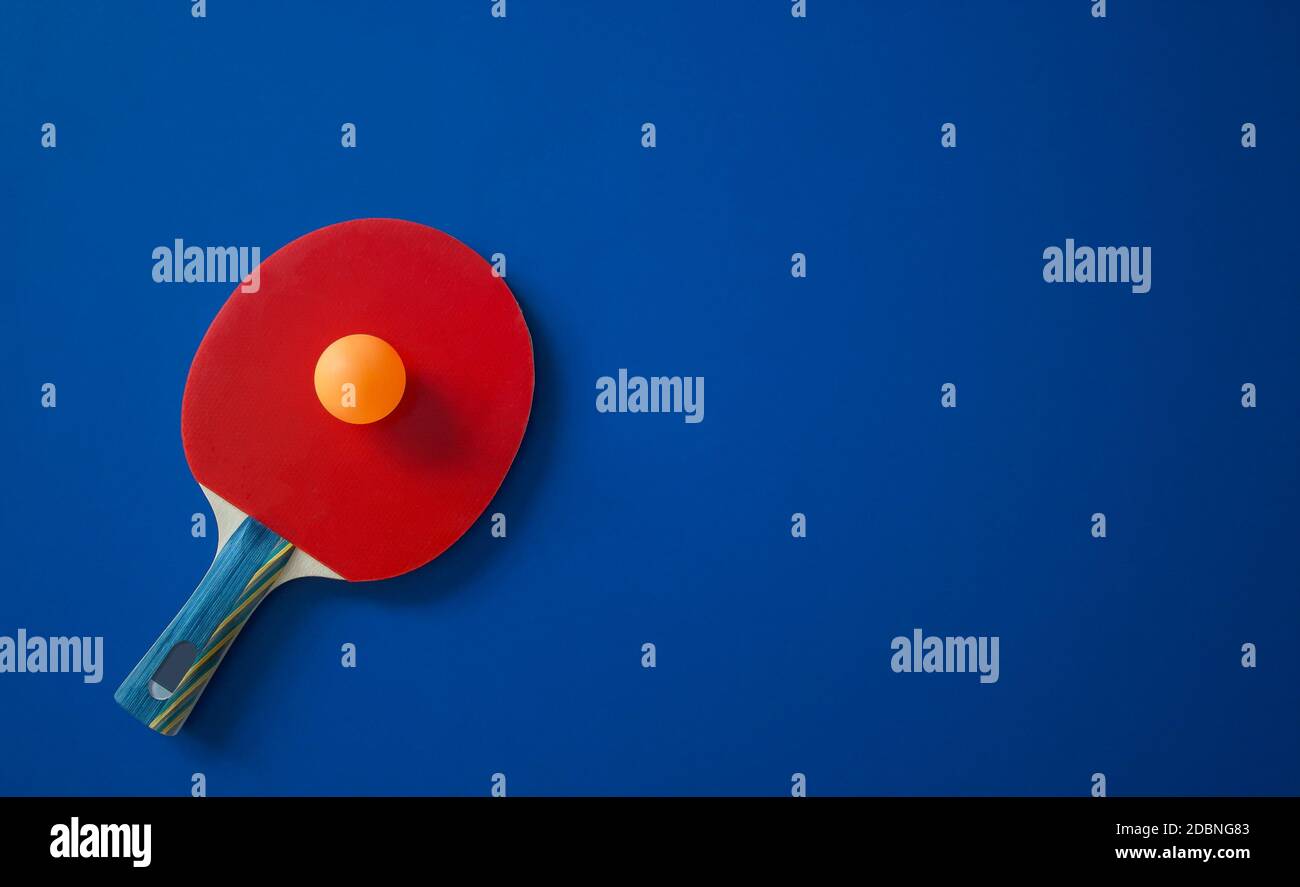 Red tennis racket lies on a blue table with a yellow ball Stock Photo ...