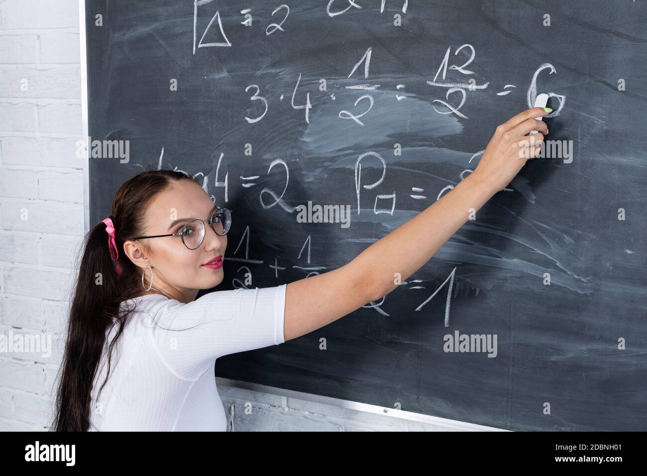 Mathematical task. Blackboard. Young teenage girl. He solves the task ...