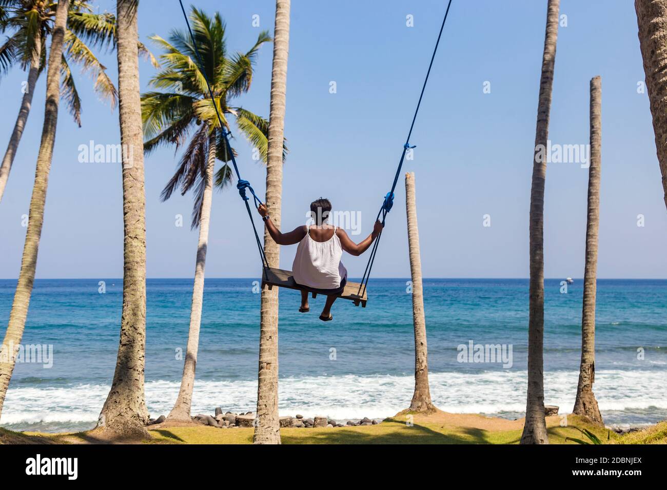 Woman on swing coconut tree hi-res stock photography and images - Alamy