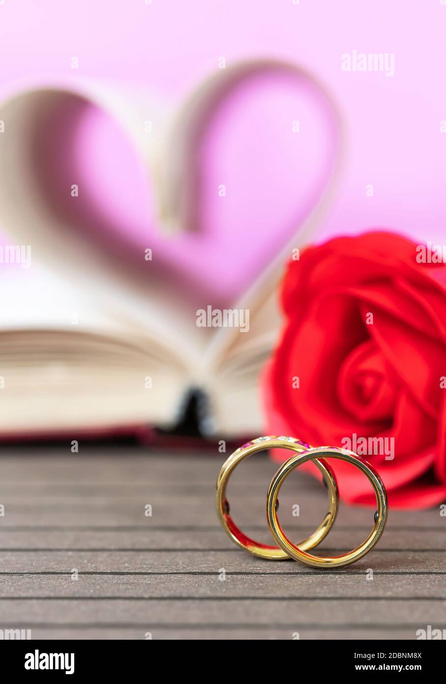 Wedding ring pages of book curved into a heart shape and red rose,Love ...
