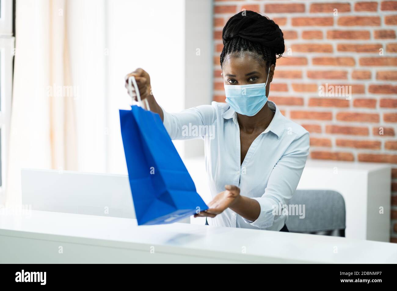 Cashier In Retail Shop Or Store At Counter Wearing Face Mask Stock ...