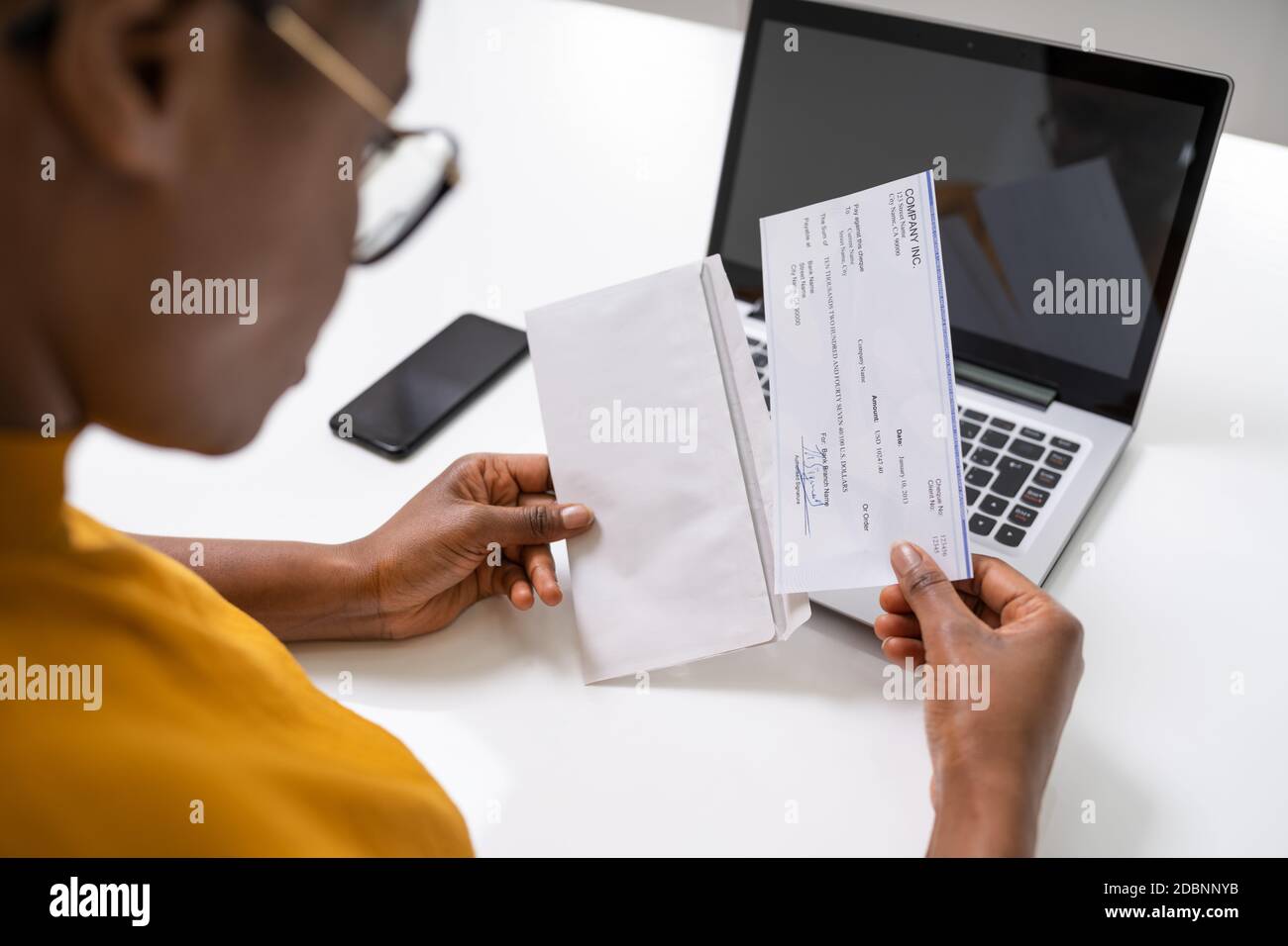 American African Holding Paycheck Or Payroll Check Stock Photo - Alamy