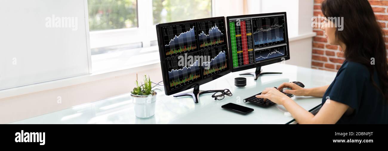 Stock Analyst Working On Multiple Computer Screens Stock Photo - Alamy