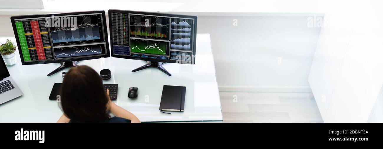 Stock Analyst Working On Multiple Computer Screens Stock Photo - Alamy