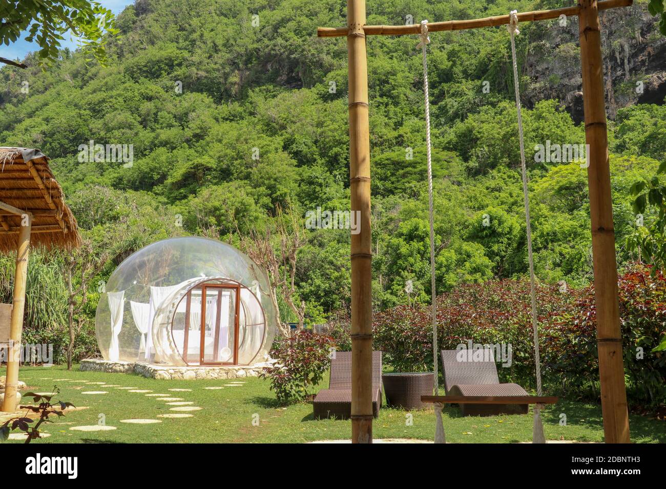 Romantic bubble house with transparent walls. White wooden double bed ...