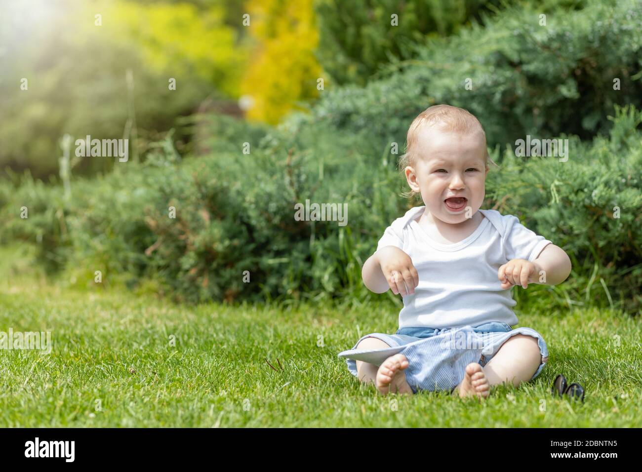 Little baby boy is crying sitting outdoors in the garden Stock Photo ...