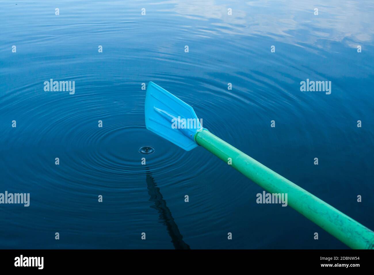 Blue paddle in water with reflections of the sky Stock Photo - Alamy