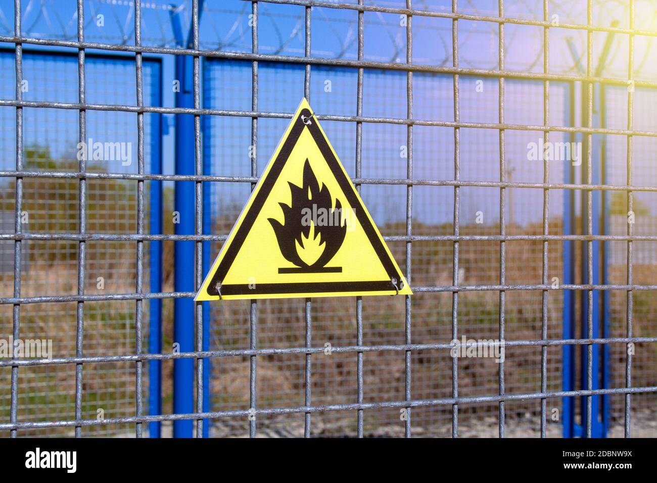 Fire danger yellow sign on metallic grid Stock Photo - Alamy