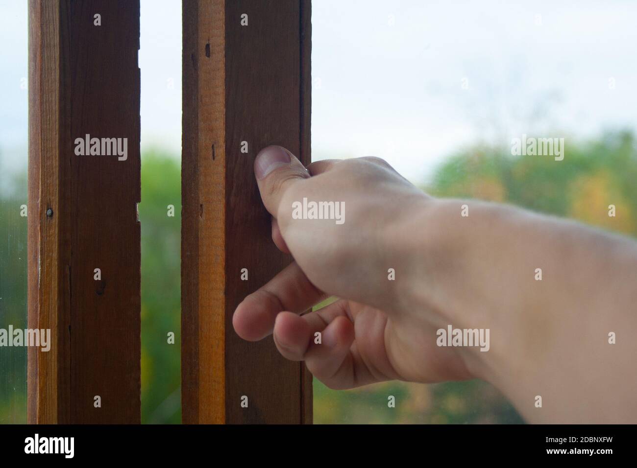 Hand closing the window at cold weather. Winter is coming, close window ...