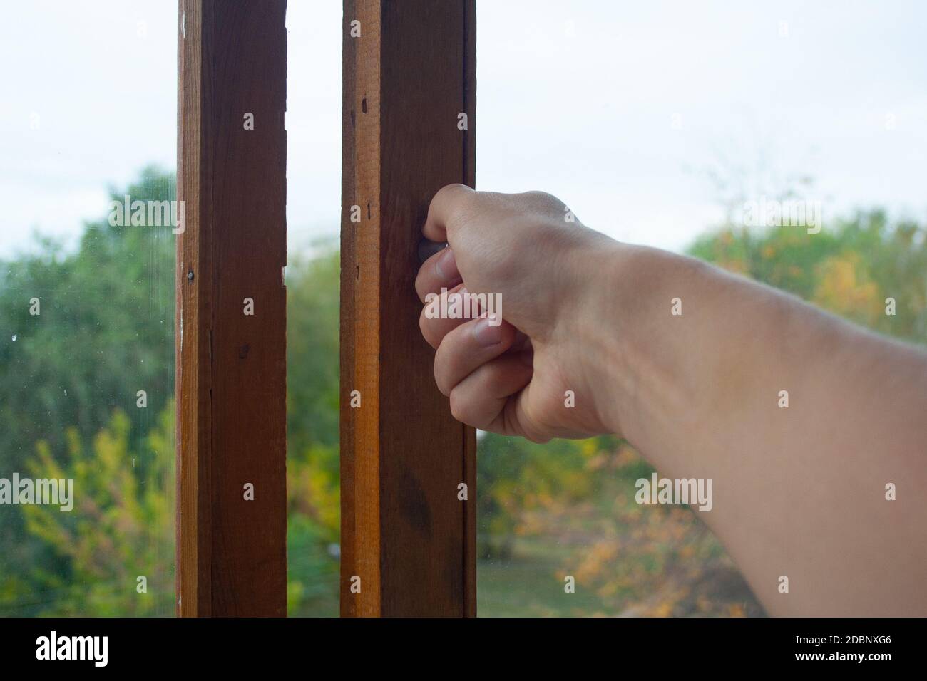 Hand closing the window at cold weather. Winter is coming, close window ...