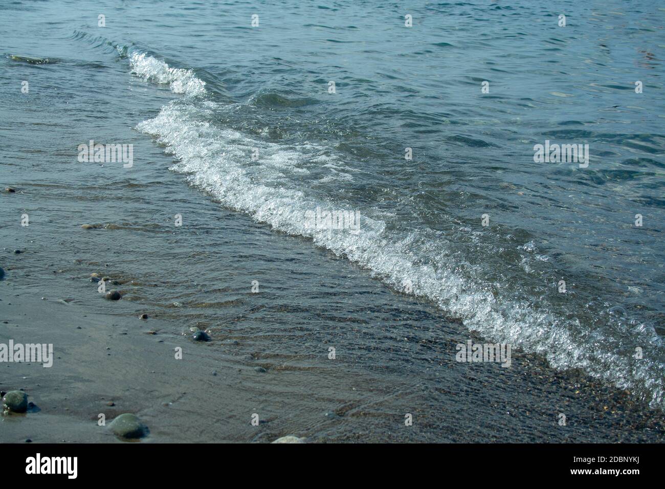 Stone beach with waves. Multi colore stones on beach Stock Photo - Alamy