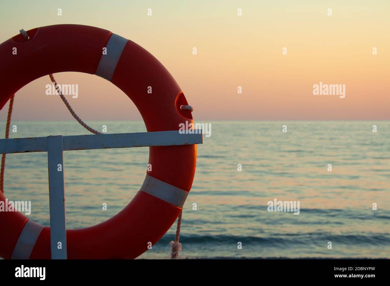 Orange life ring near sea on sunset. Saving life concept Stock Photo ...
