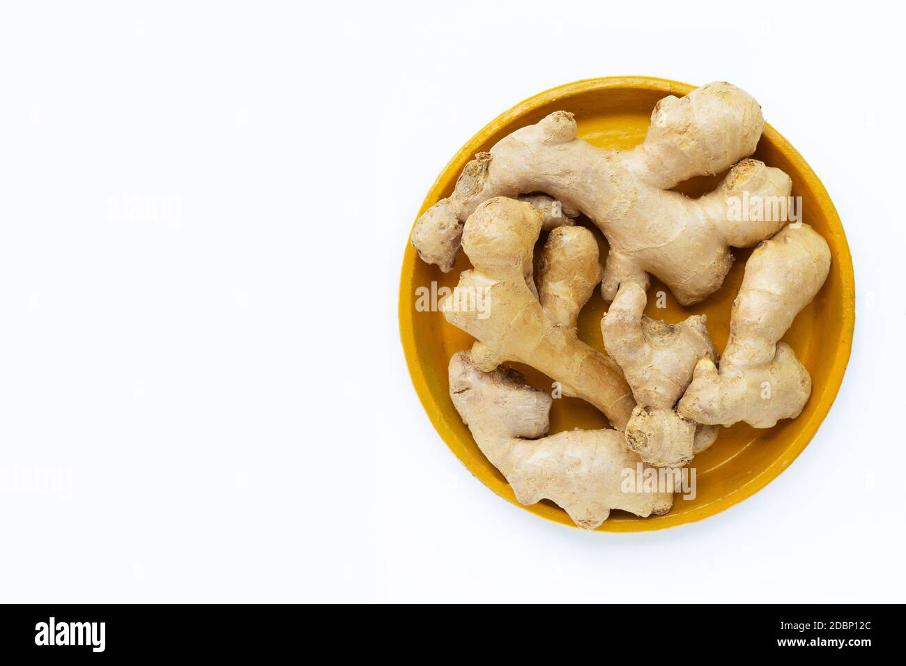 Ginger on yellow plate on white background Stock Photo - Alamy