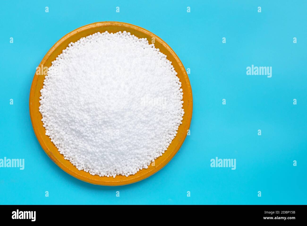 Chemical plant urea fertilizer on pottery plate on blue background ...