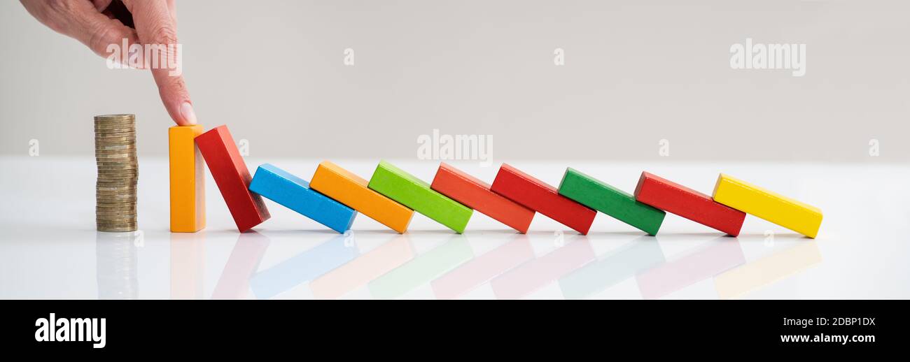 Hand Stopping Wooden Domino Chain From Falling Stock Photo - Alamy