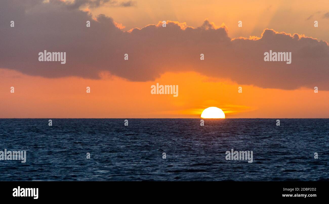 Sun Setting at Sea Stock Photo - Alamy