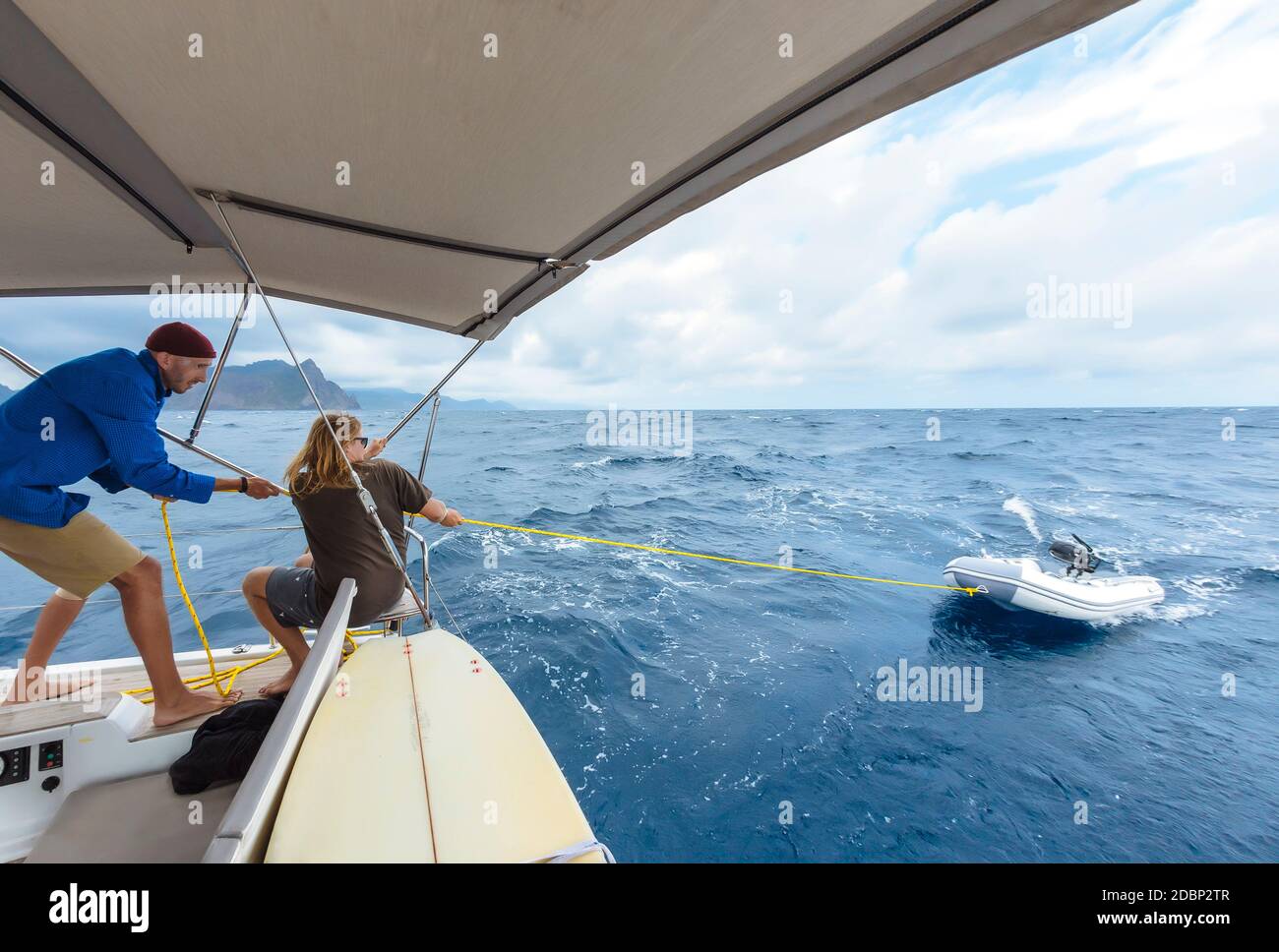 Two men pulling inflatable raft on sailboat, Lombok, Indonesia Stock ...
