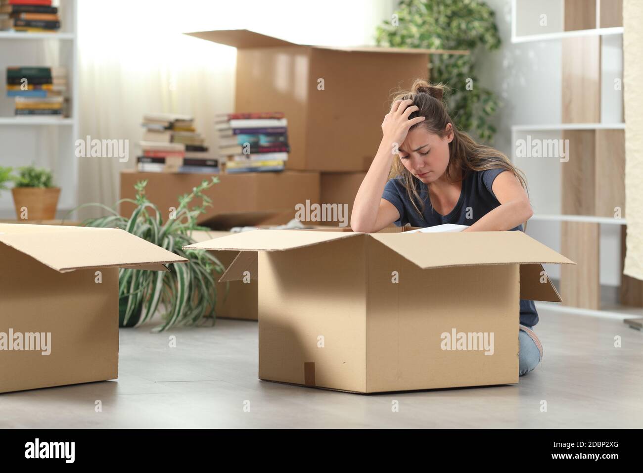 Sad evicted woman complaining moving out packing boxes sitting on the ...