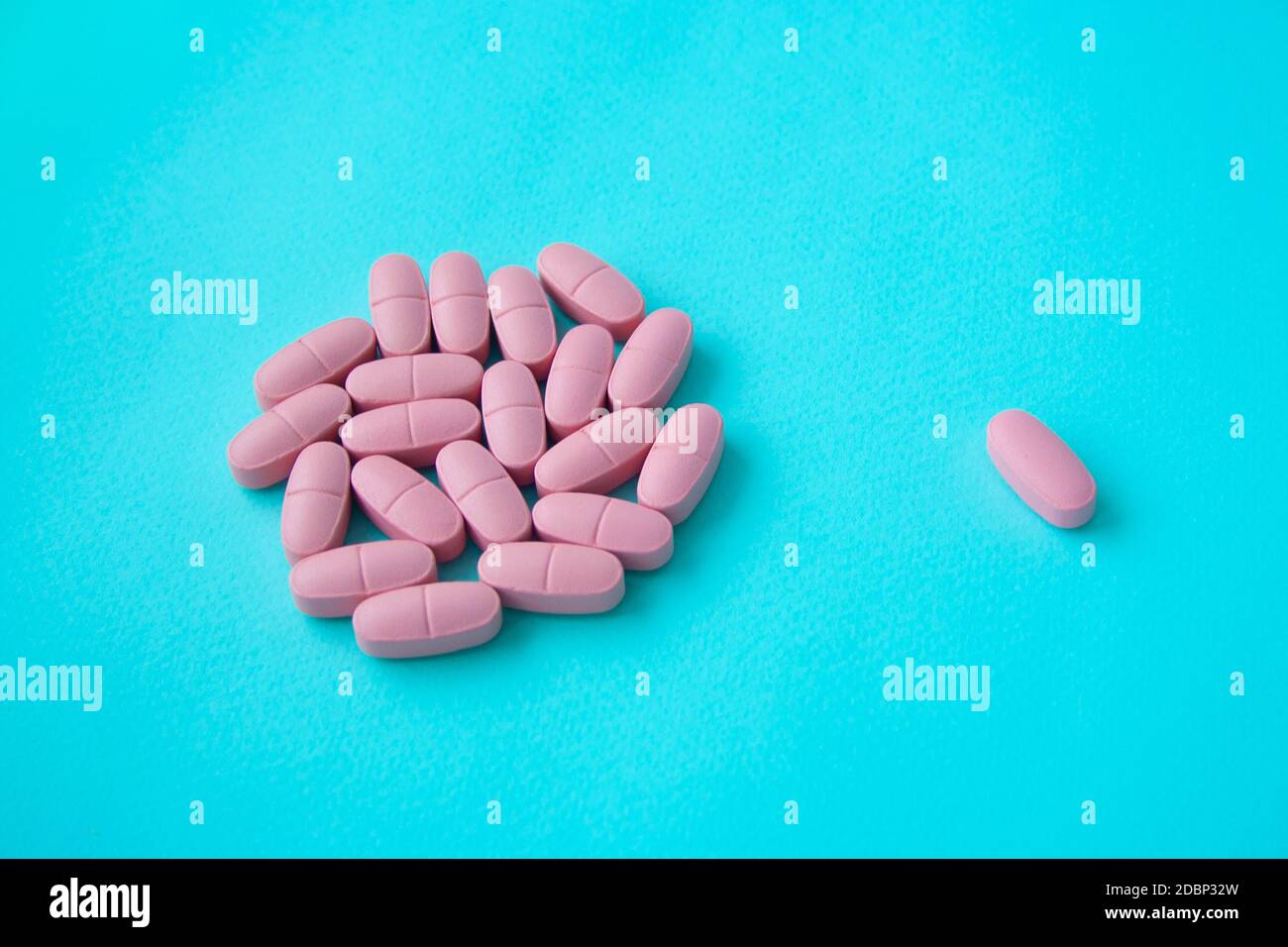 Calcium pink pills close up on blue background. Medicine concept. Food ...
