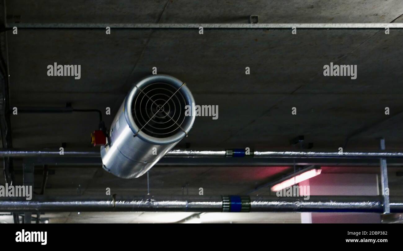 An air conditioning fan unit in an underground car park surrounded by ...