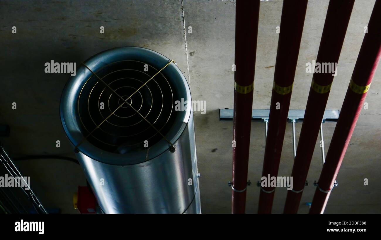 An air conditioning fan unit in an underground car park surrounded by ...