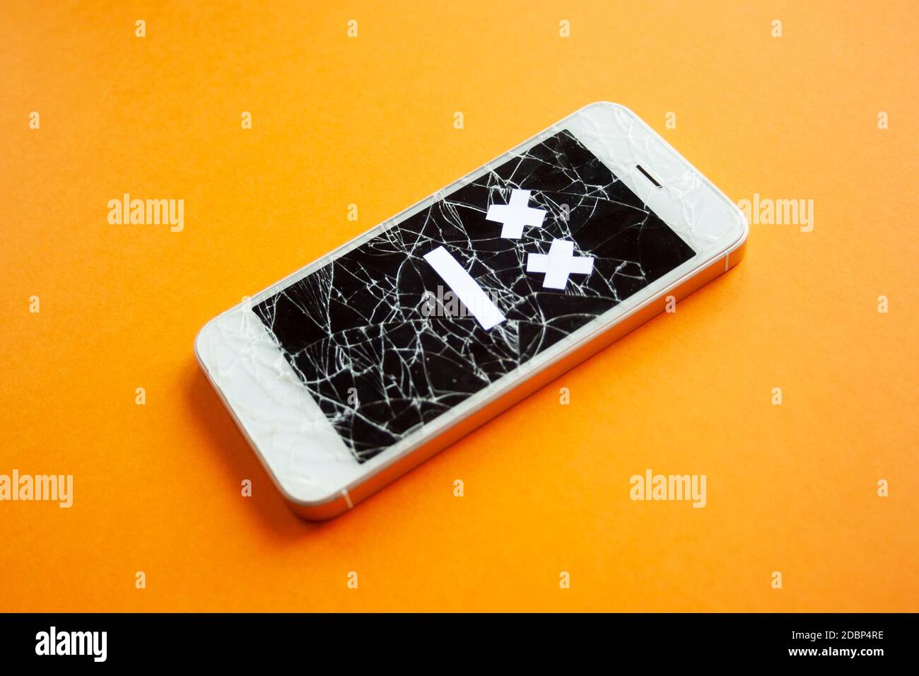 Broken smartphone with cracked destroyed screen on orange background ...