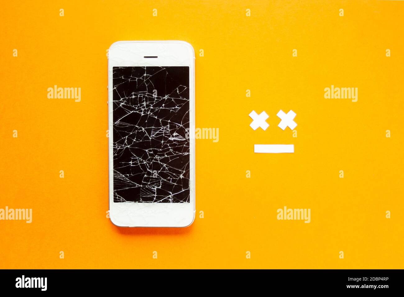 Broken smartphone with cracked destroyed screen on orange background ...
