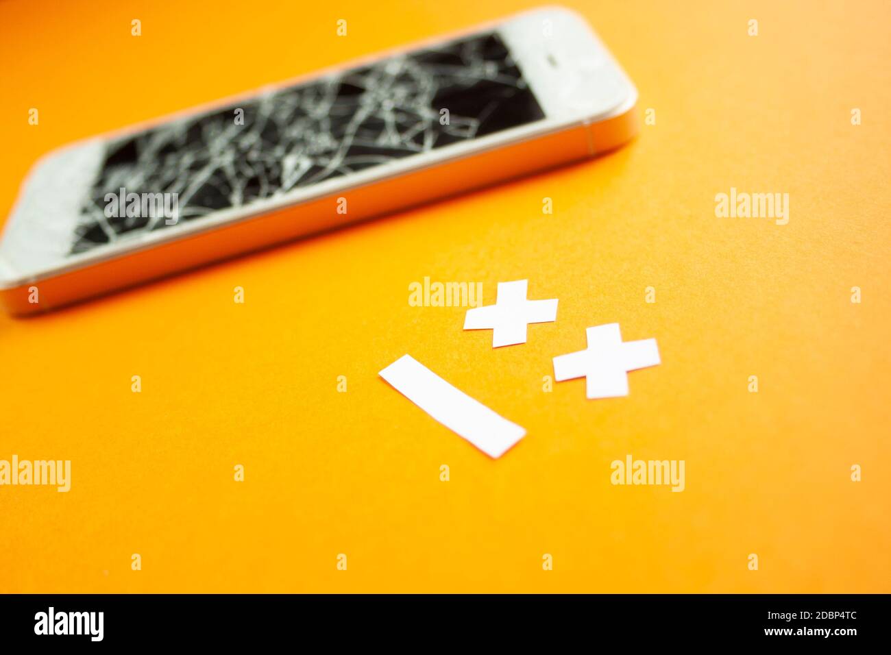 Broken smartphone with cracked destroyed screen on orange background ...