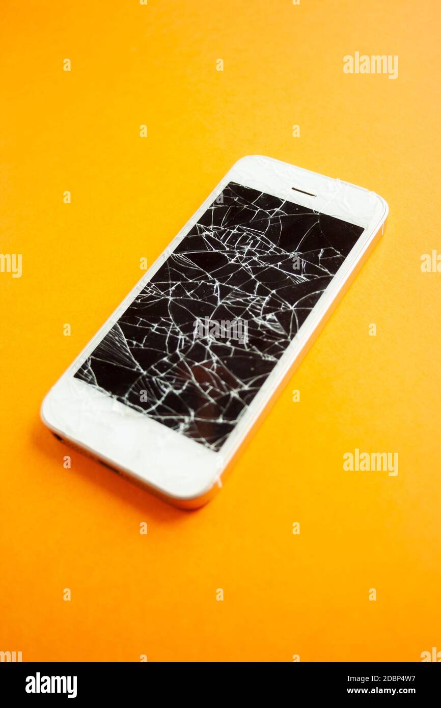 Broken screen of smartphone on the orange background. Smashed glass of ...