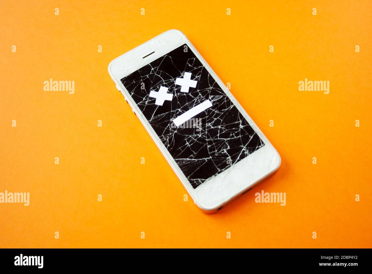 Broken smartphone with cracked destroyed screen on orange background ...