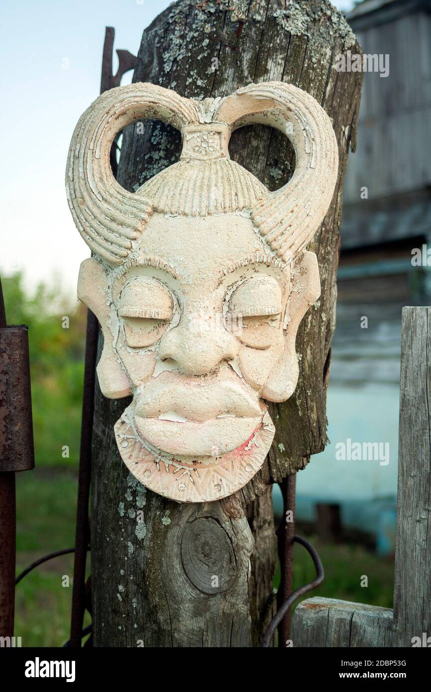 Old african ancient handmade mask on wooden fence near house. African ...