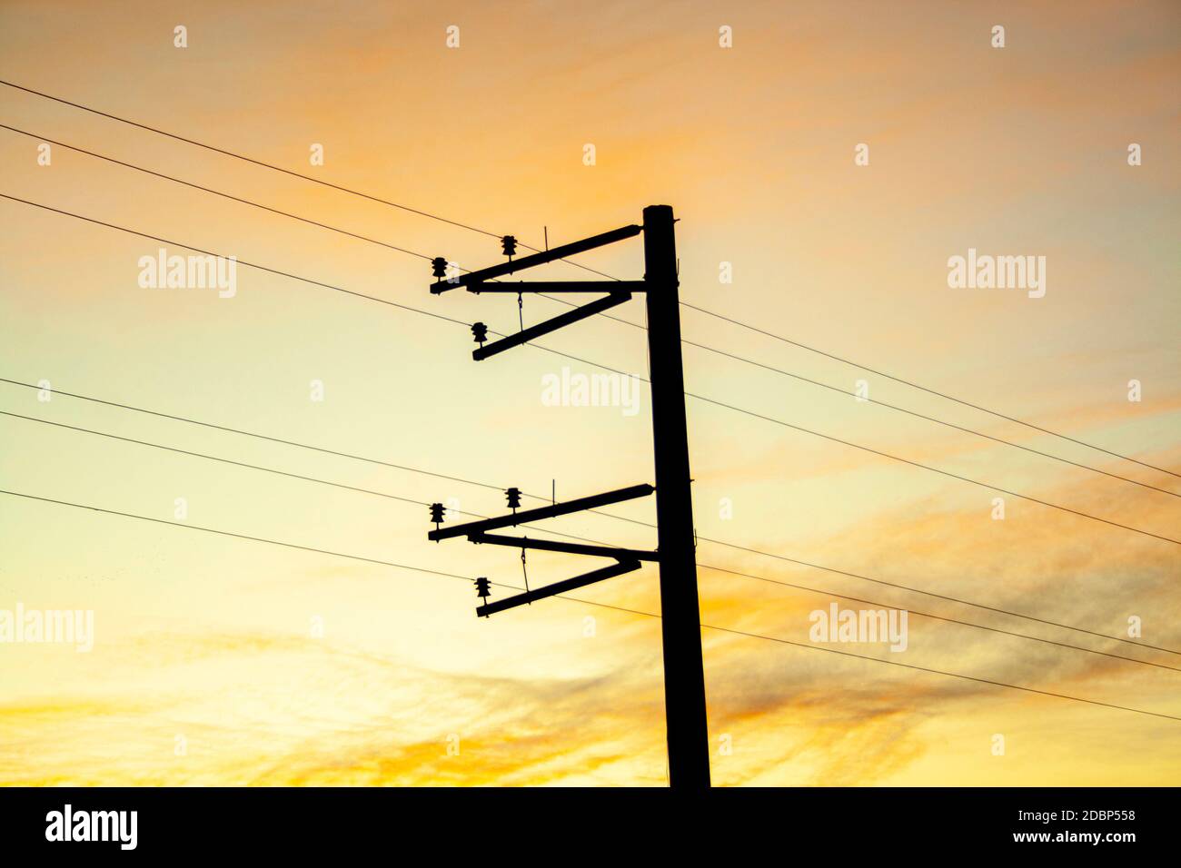 Electric pole shape against the sunset orange sky. Mobile communication ...