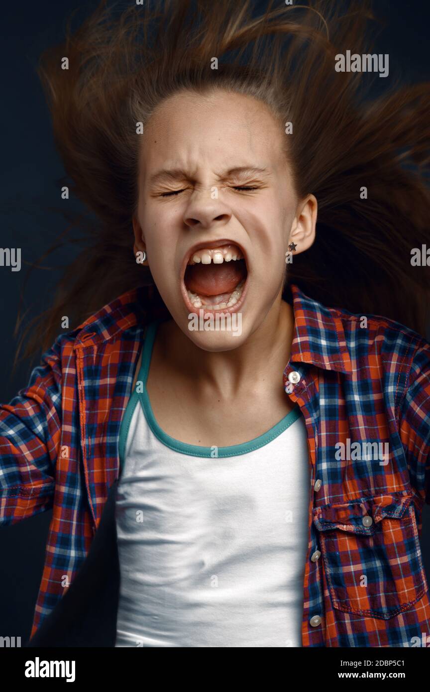 Little girl shouting in studio, developing hair effect. Children and ...