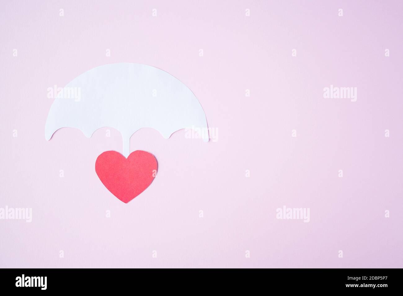 Red paper heart shape under white paper umbrella as life, health ...