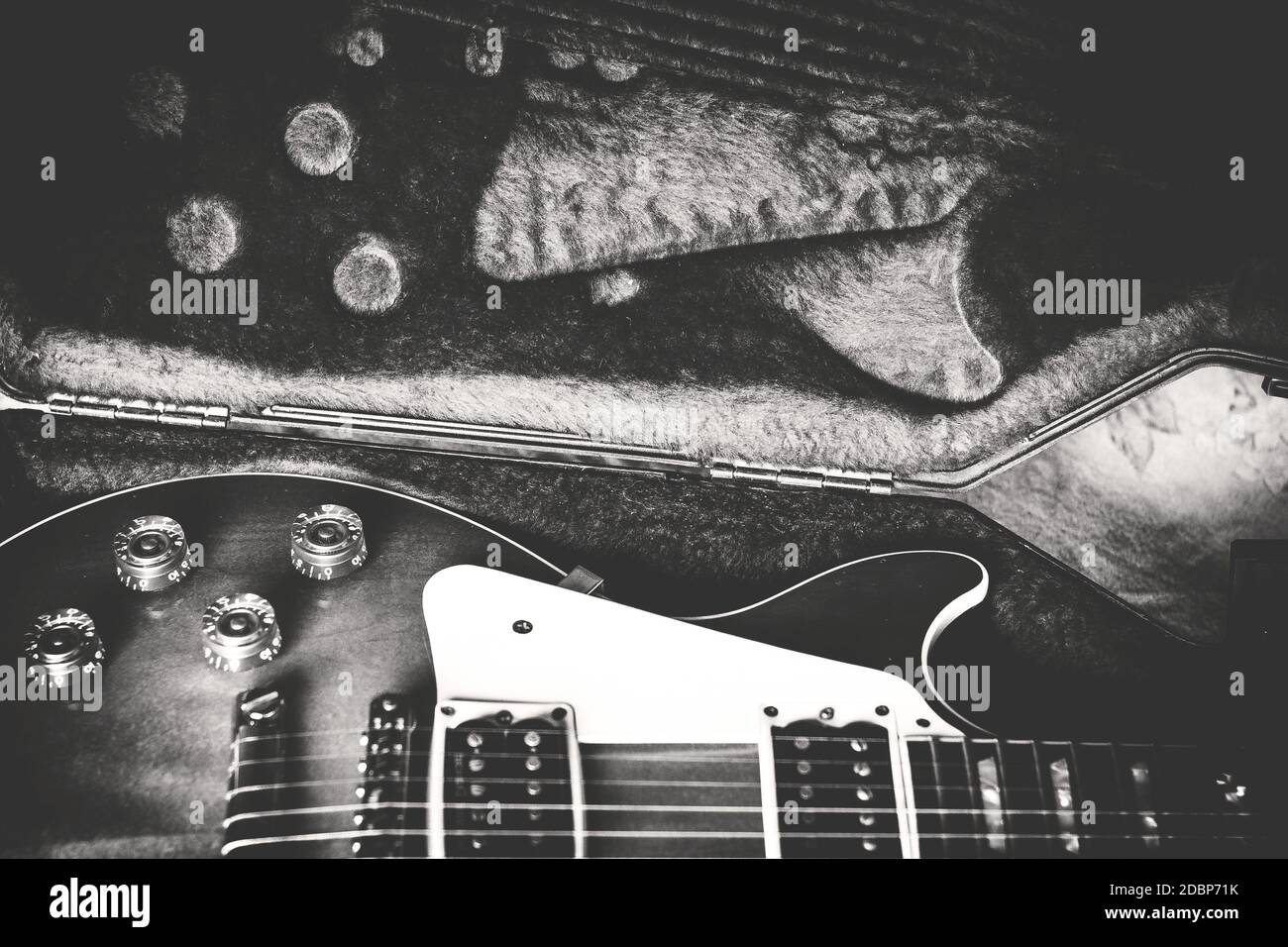 Black and white close-up of an electric guitar laying inside a guitar ...