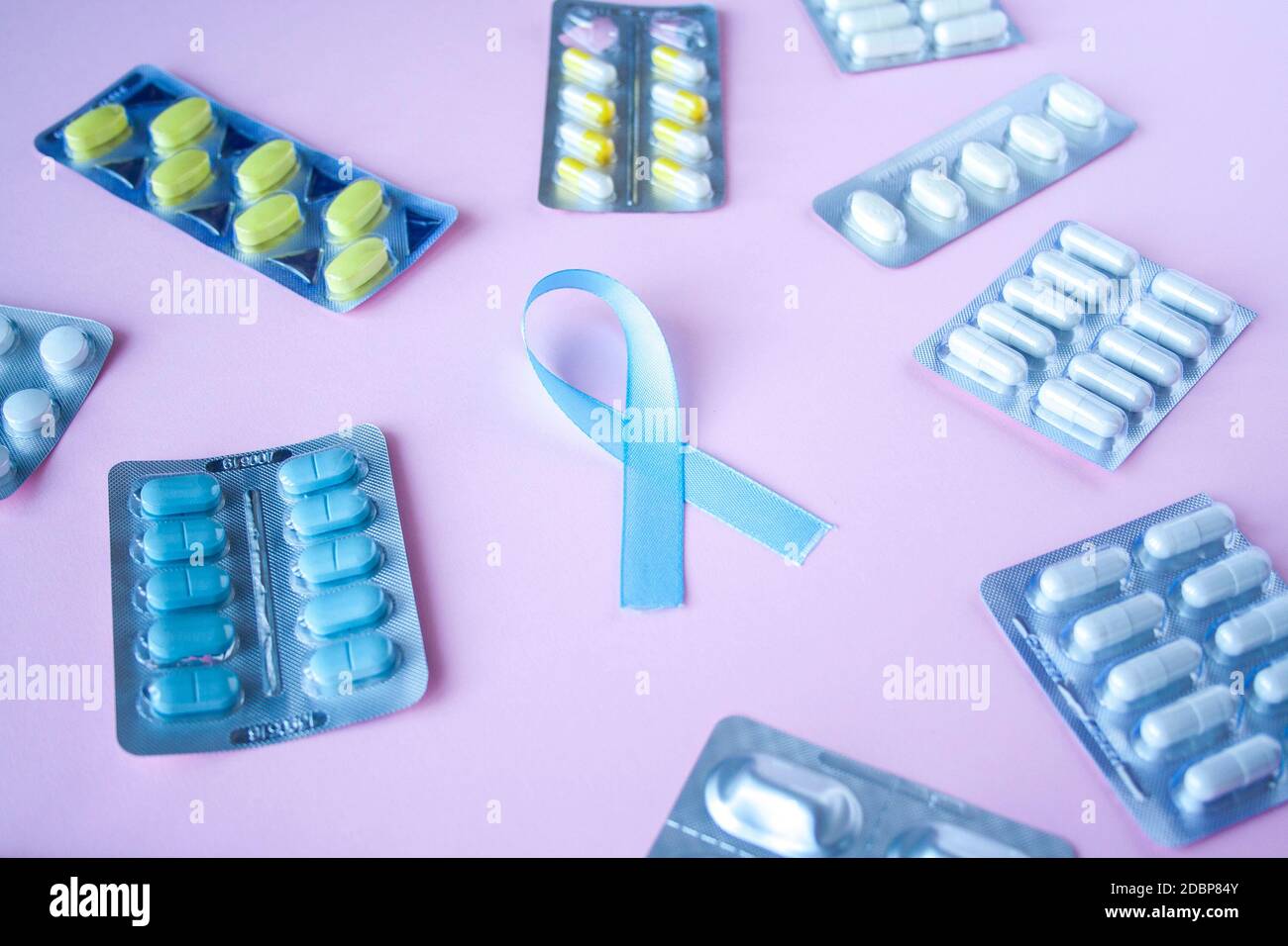 Blue ribbon symbol of prostate cancer with many pills and drugs ...
