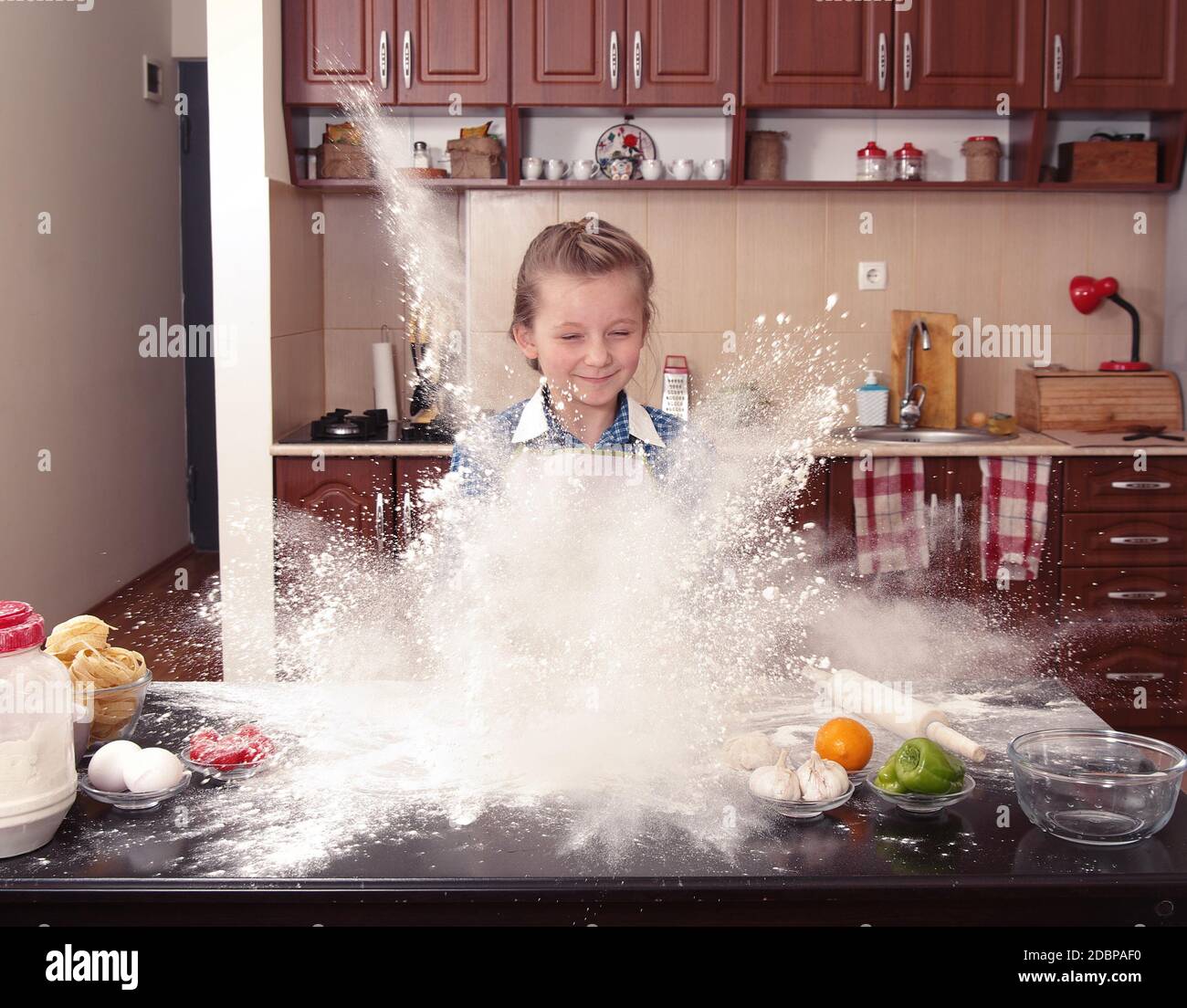 little girl is helping to bake in a messy kitchen Stock Photo - Alamy