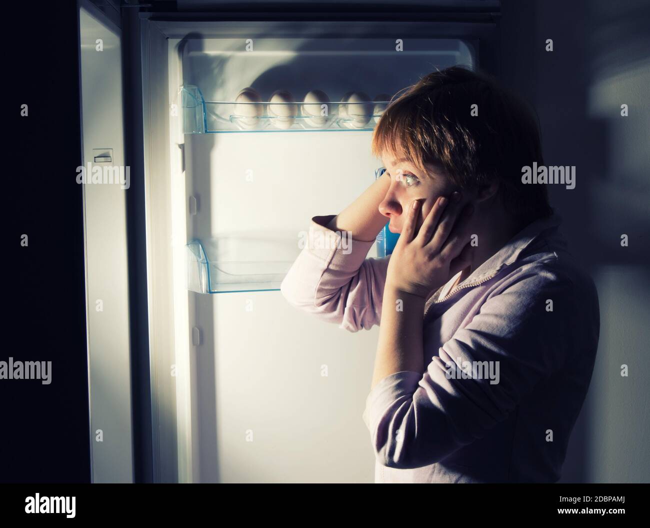shocked woman looking into refrigerator Stock Photo - Alamy