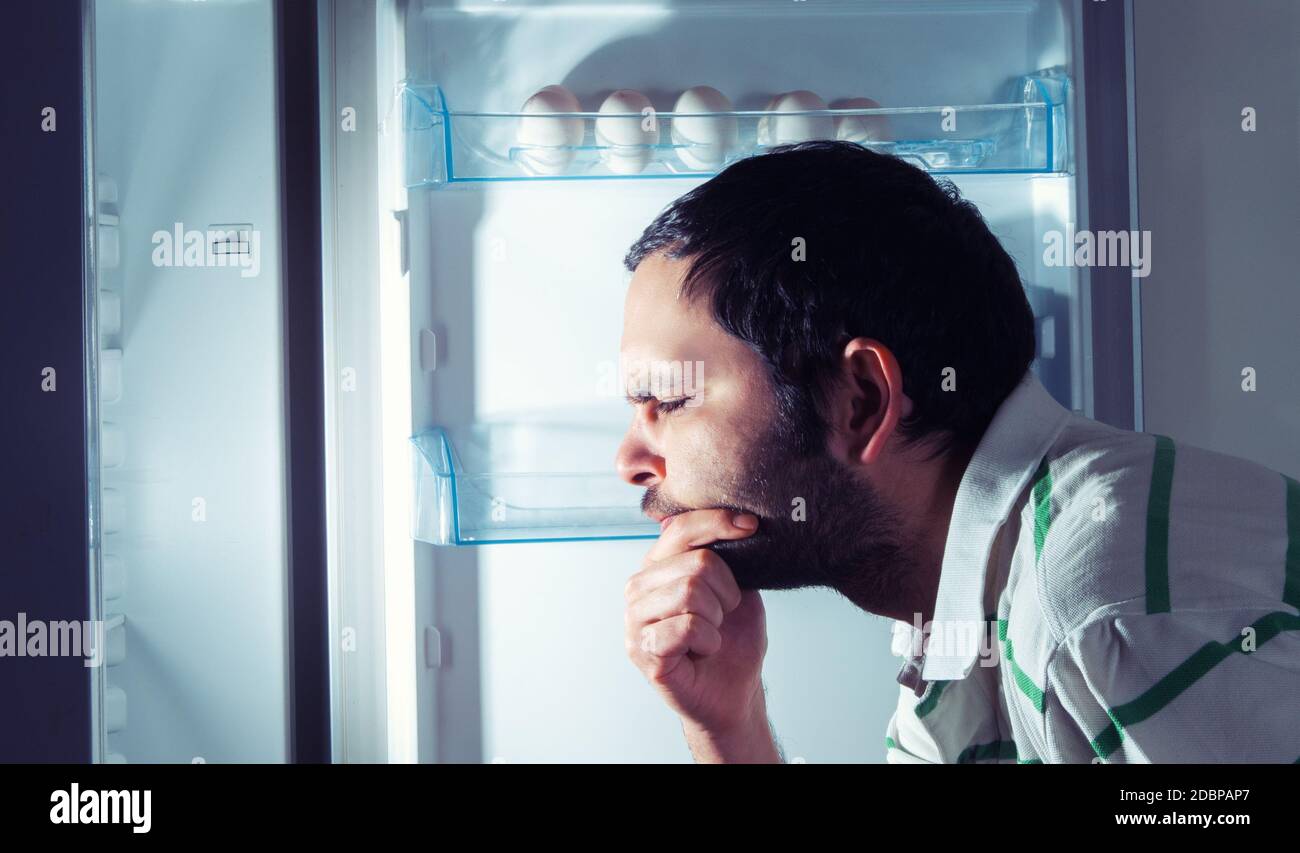 funny man looking into refrigerator Stock Photo - Alamy
