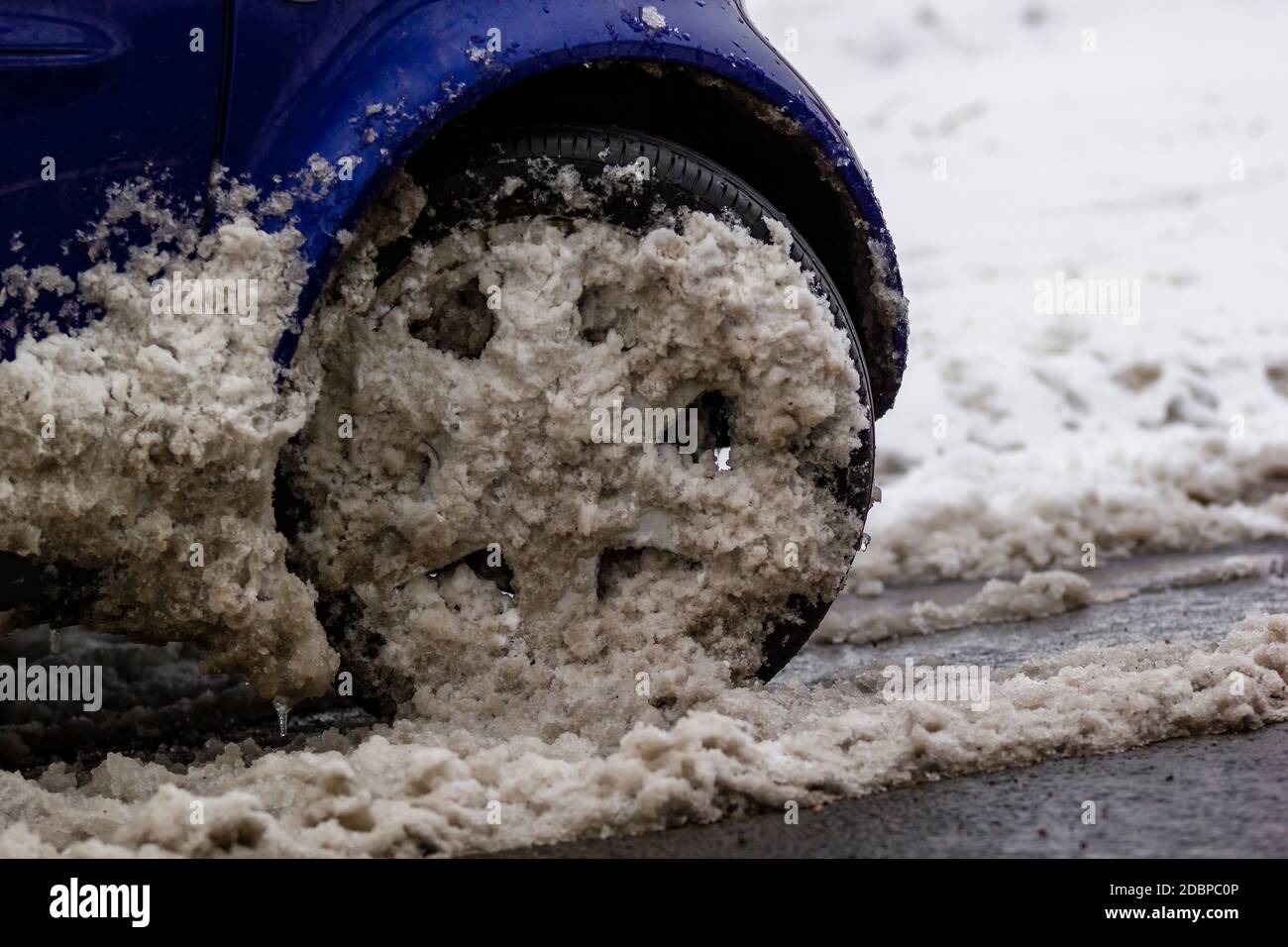A car driving through snow, slush and ice on a road in winter Stock ...