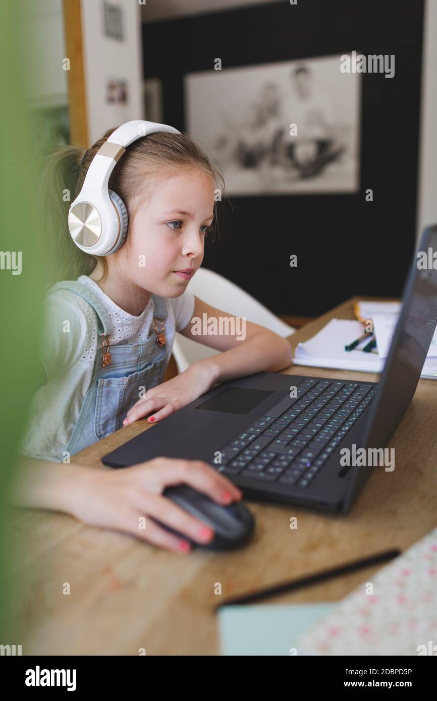 young girl with headphones and laptop is doing homeschooling Stock ...