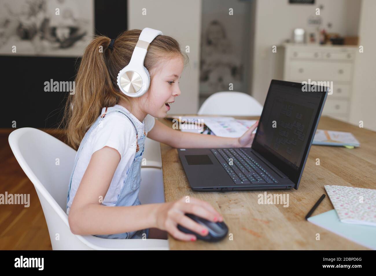 young girl with headphones and laptop is doing homeschooling Stock ...