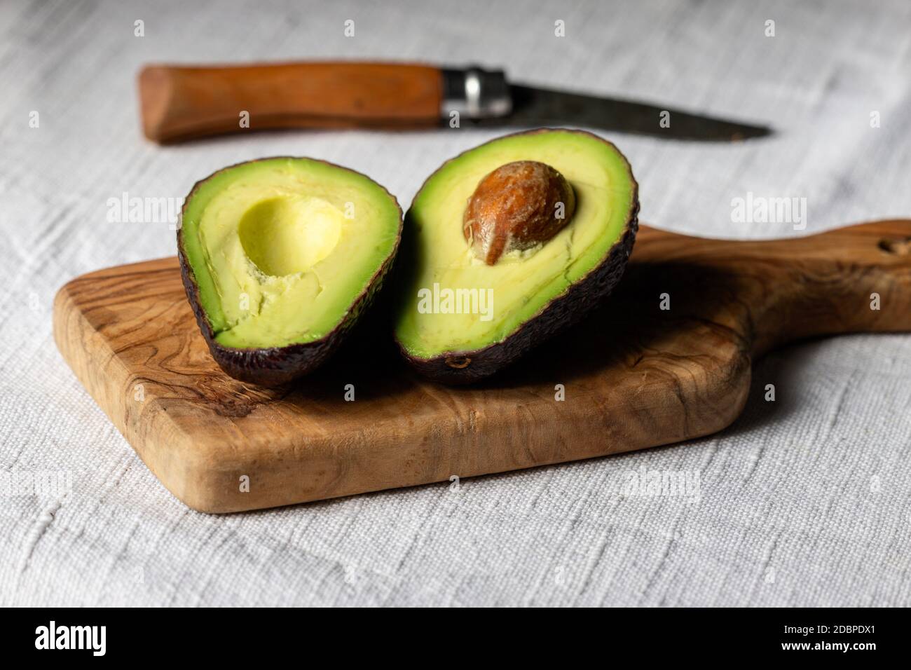 halves of avocado on a board Stock Photo - Alamy