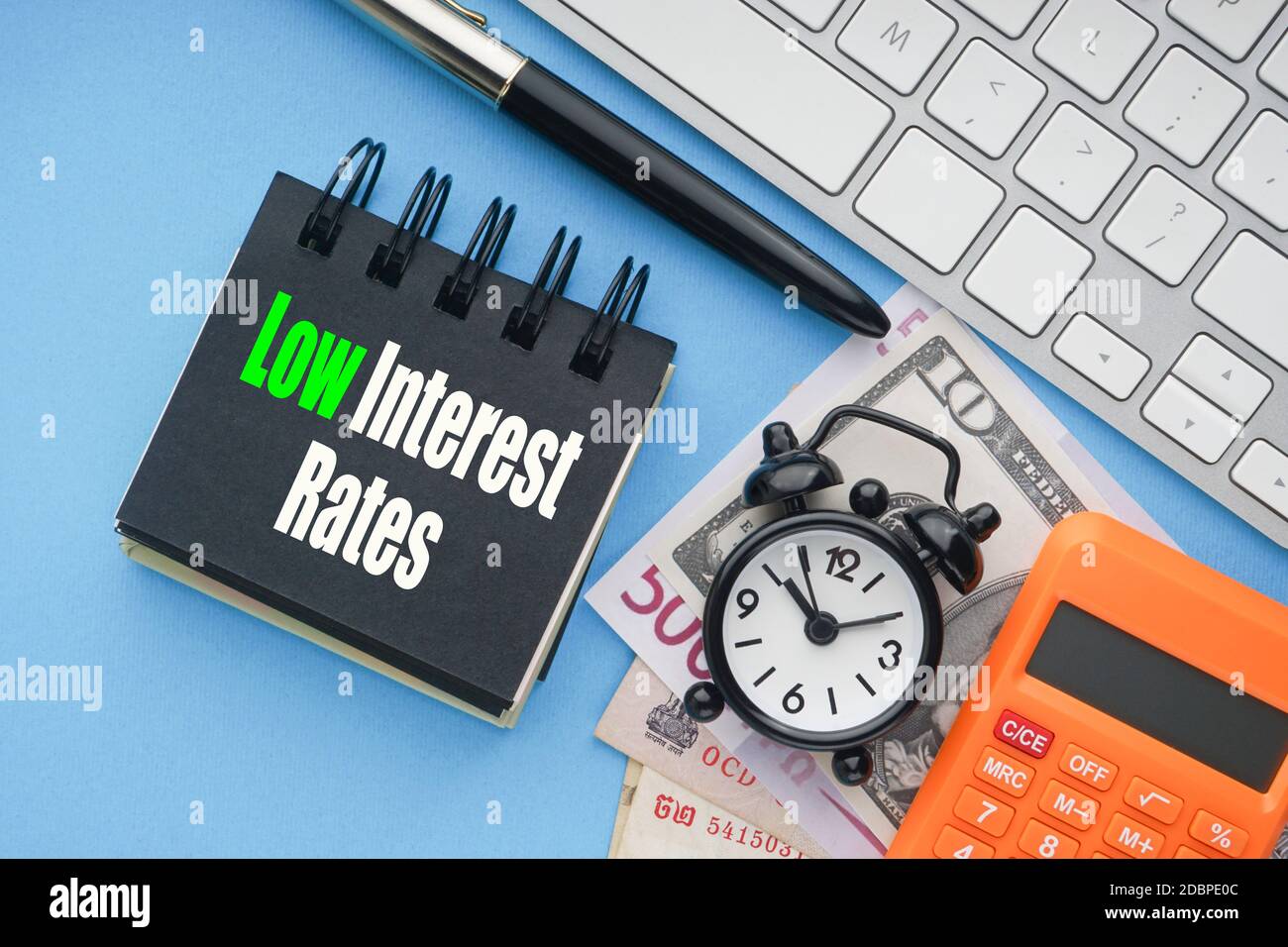 LOW INTEREST RATES text with keyboard, fountain pen, alarm clock ...
