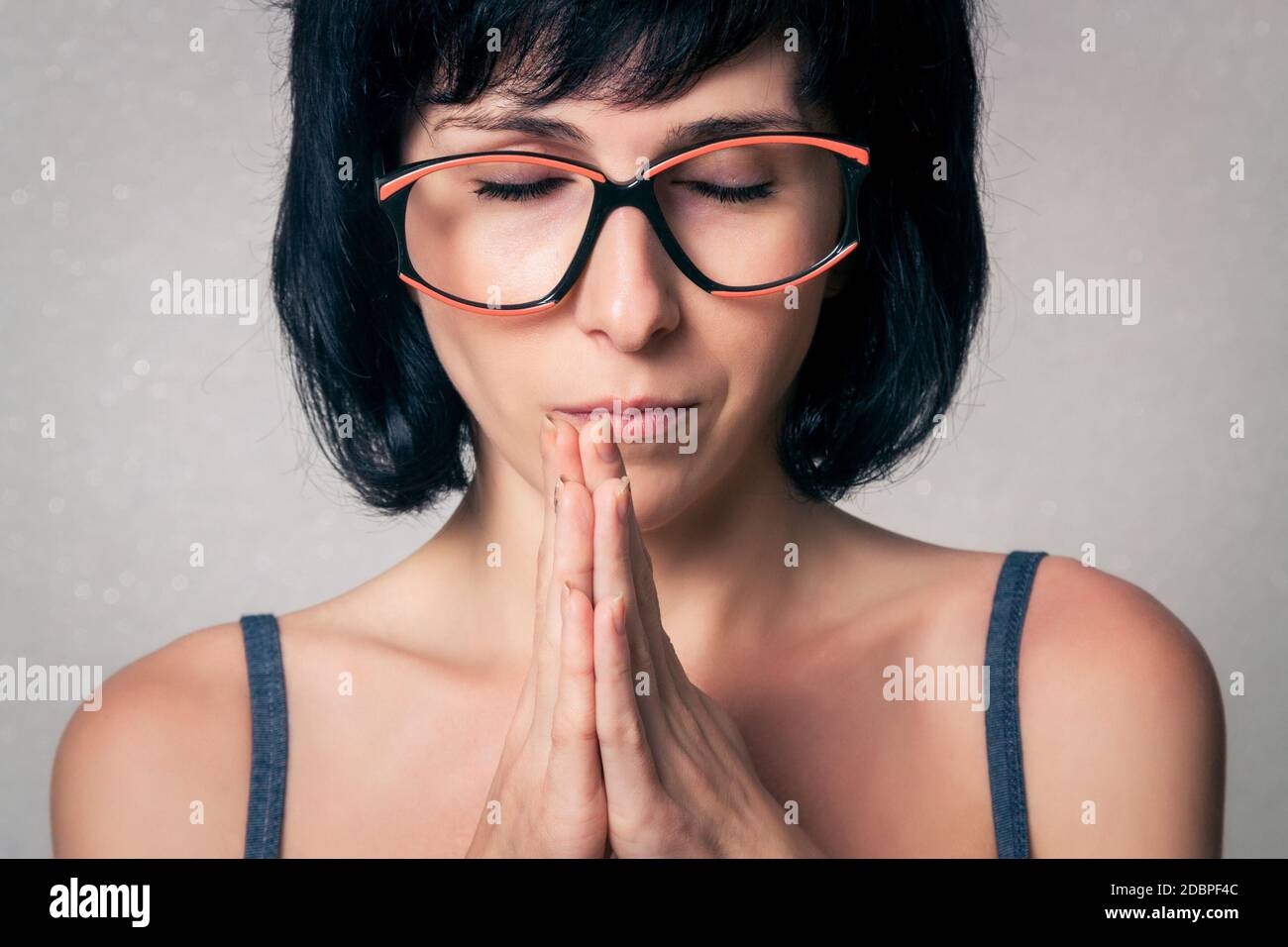Pretty woman with praying sign Stock Photo - Alamy