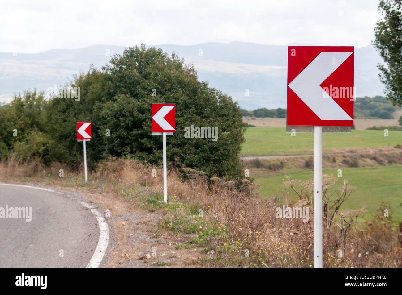 Turn signs on the mountain road Stock Photo - Alamy